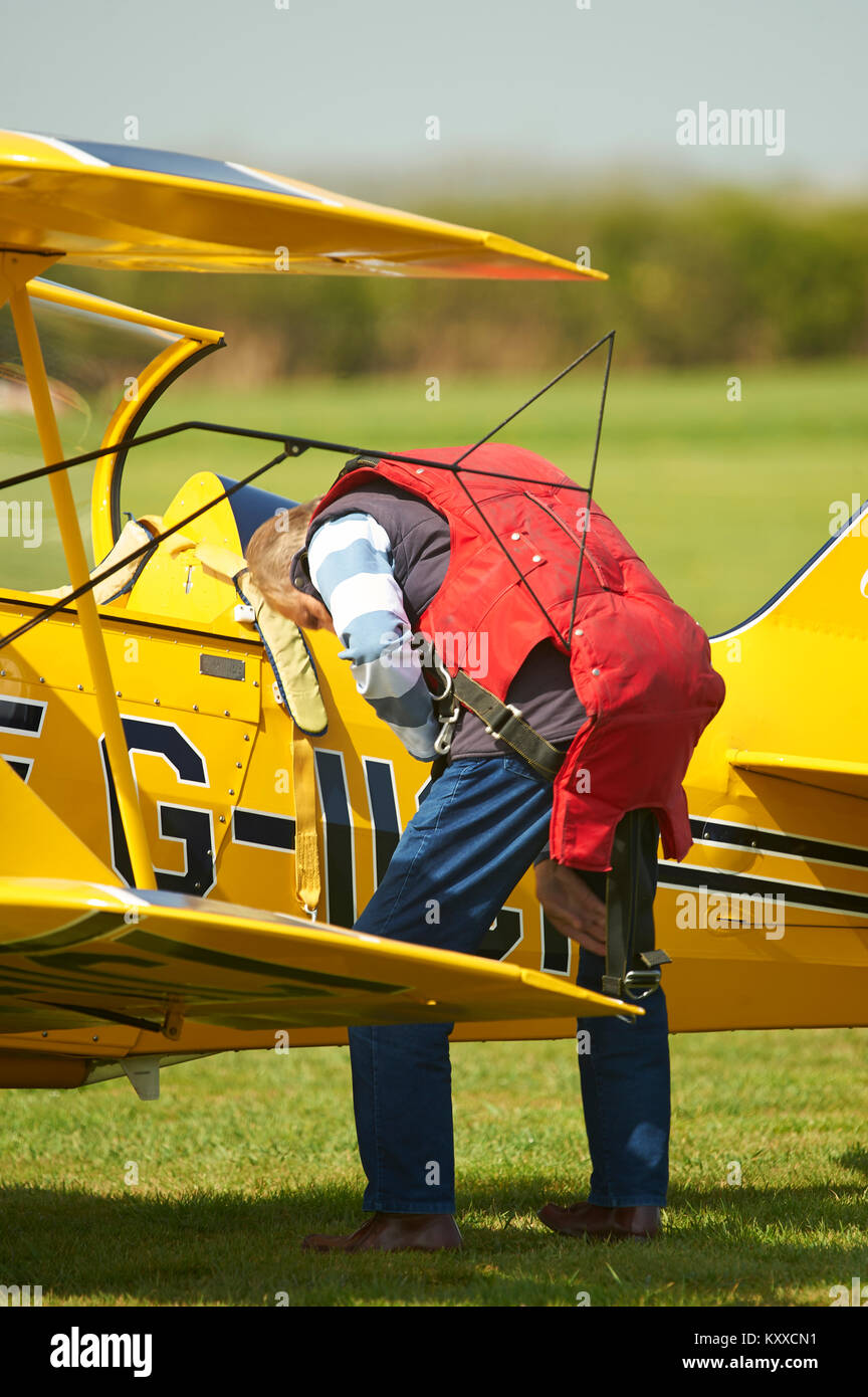 A stunt Pilot fastening his parachute at the side of his Pitts special ...