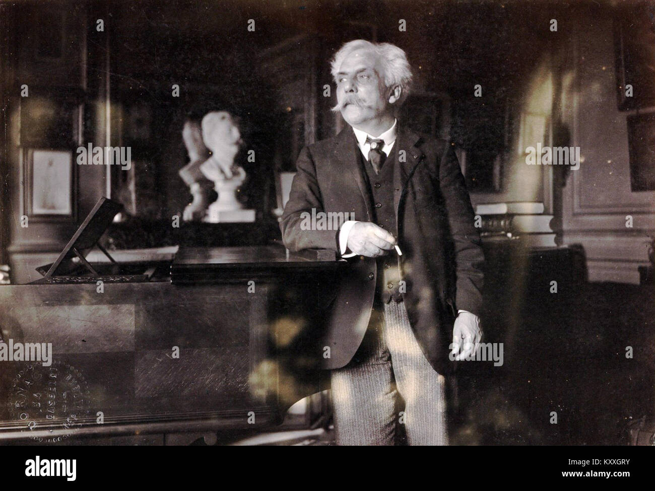 A photograph of French composer Gabriel Fauré seated at his piano in ...