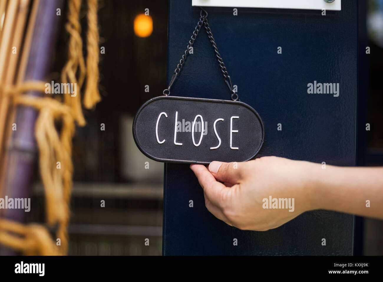 Close up of person turning closed sign on glass door to a bakery Stock ...