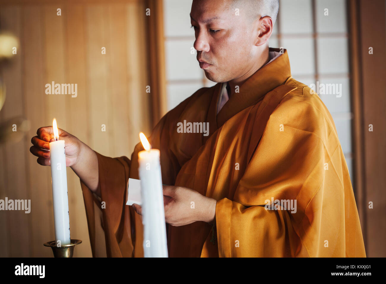 Side view of Buddhist monk with shaved head wearing golden robe ...