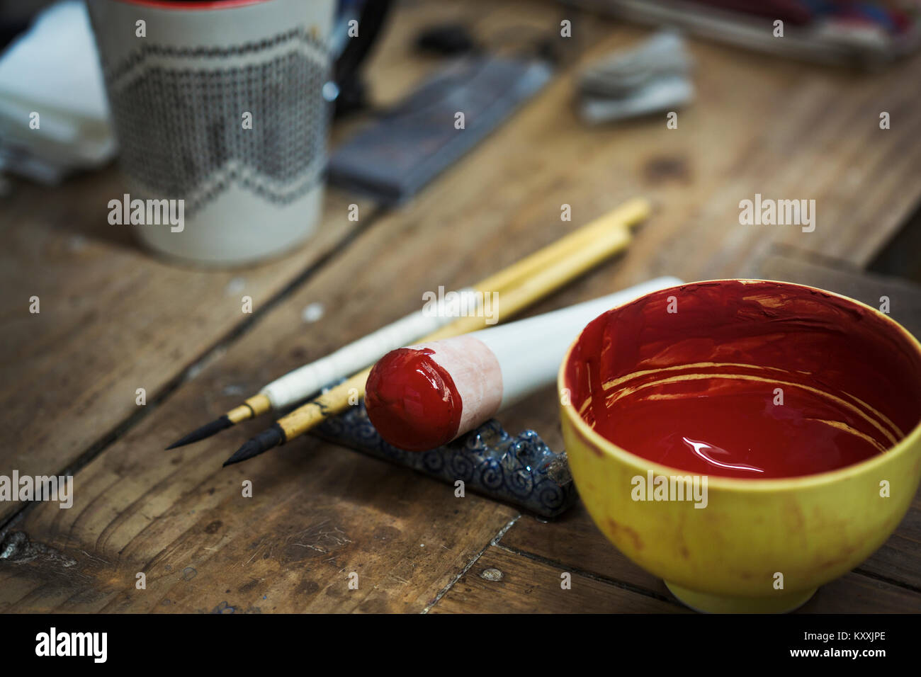 Close up materials in a Japanese porcelain workshop, bowl with red ...