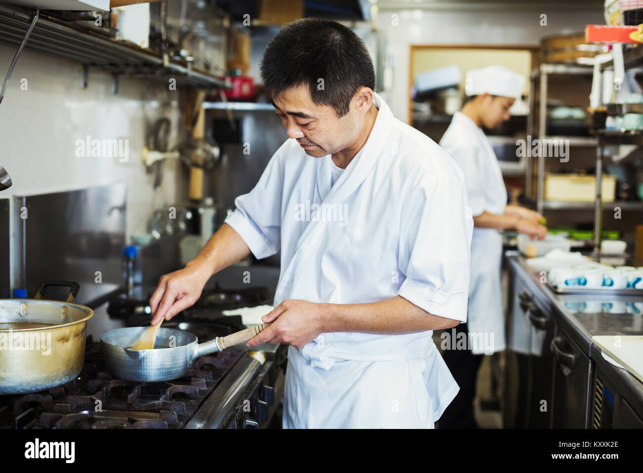 Chef working in the kitchen of a Japanese sushi restaurant, cooking on ...