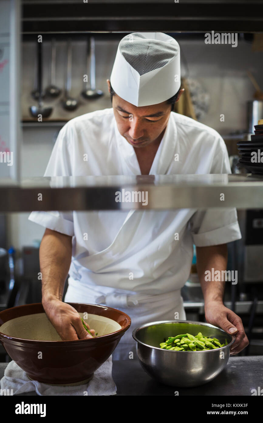 Chef working in the kitchen of a Japanese sushi restaurant, preparing ...