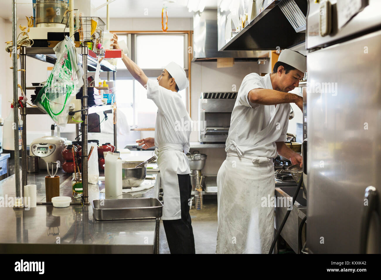 Two chefs working in the kitchen of a Japanese sushi restaurant Stock ...