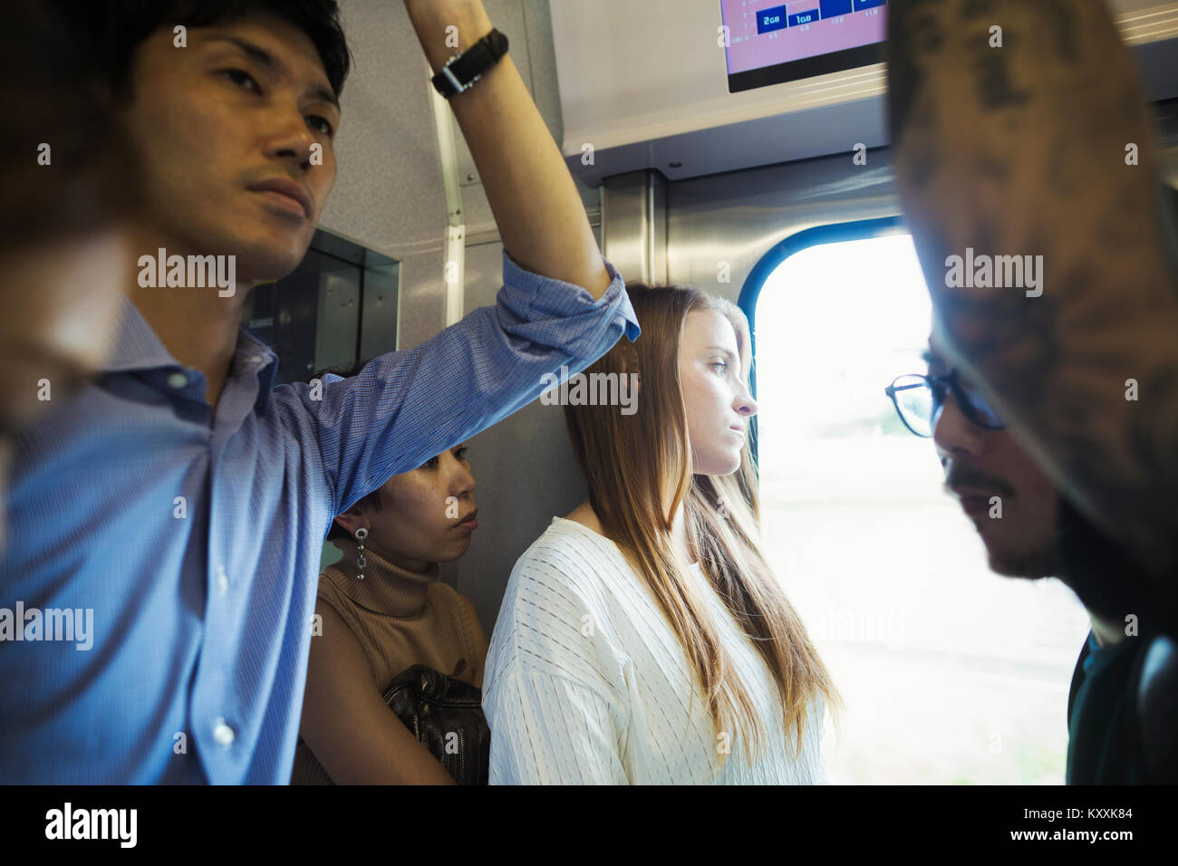 Small group of people standing on a subway train, Tokyo commuters Stock ...
