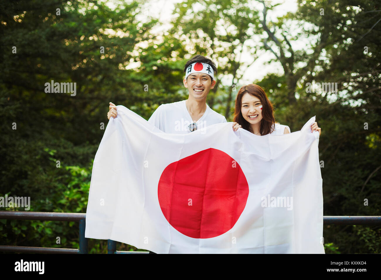 Man wearing headband and young woman with brown hair and face paint ...