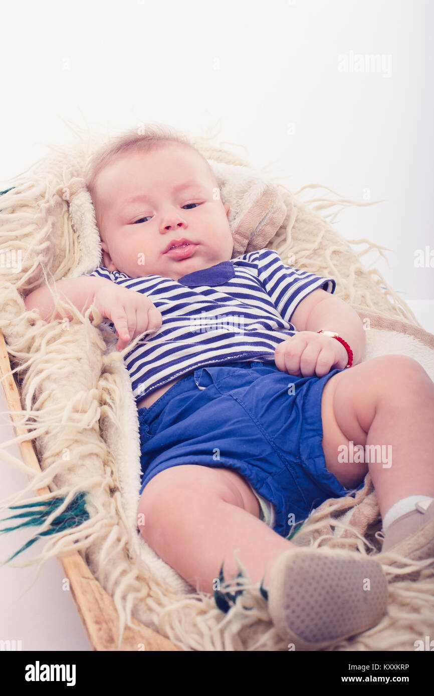 Adorable baby boy lying in a cot over white background Stock Photo - Alamy
