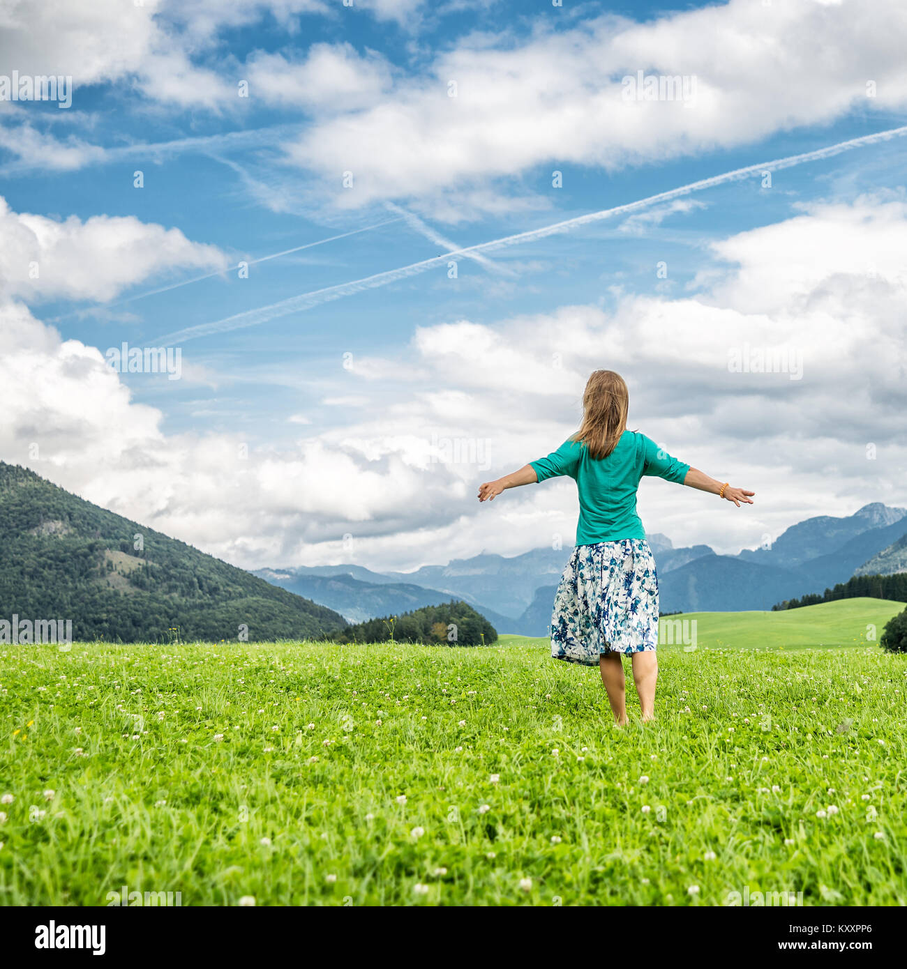 Young woman staying on the green field Stock Photo - Alamy