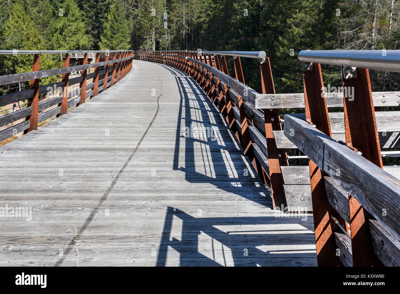 On a bright summer day shadows from the guardrail fall on the boardwalk ...