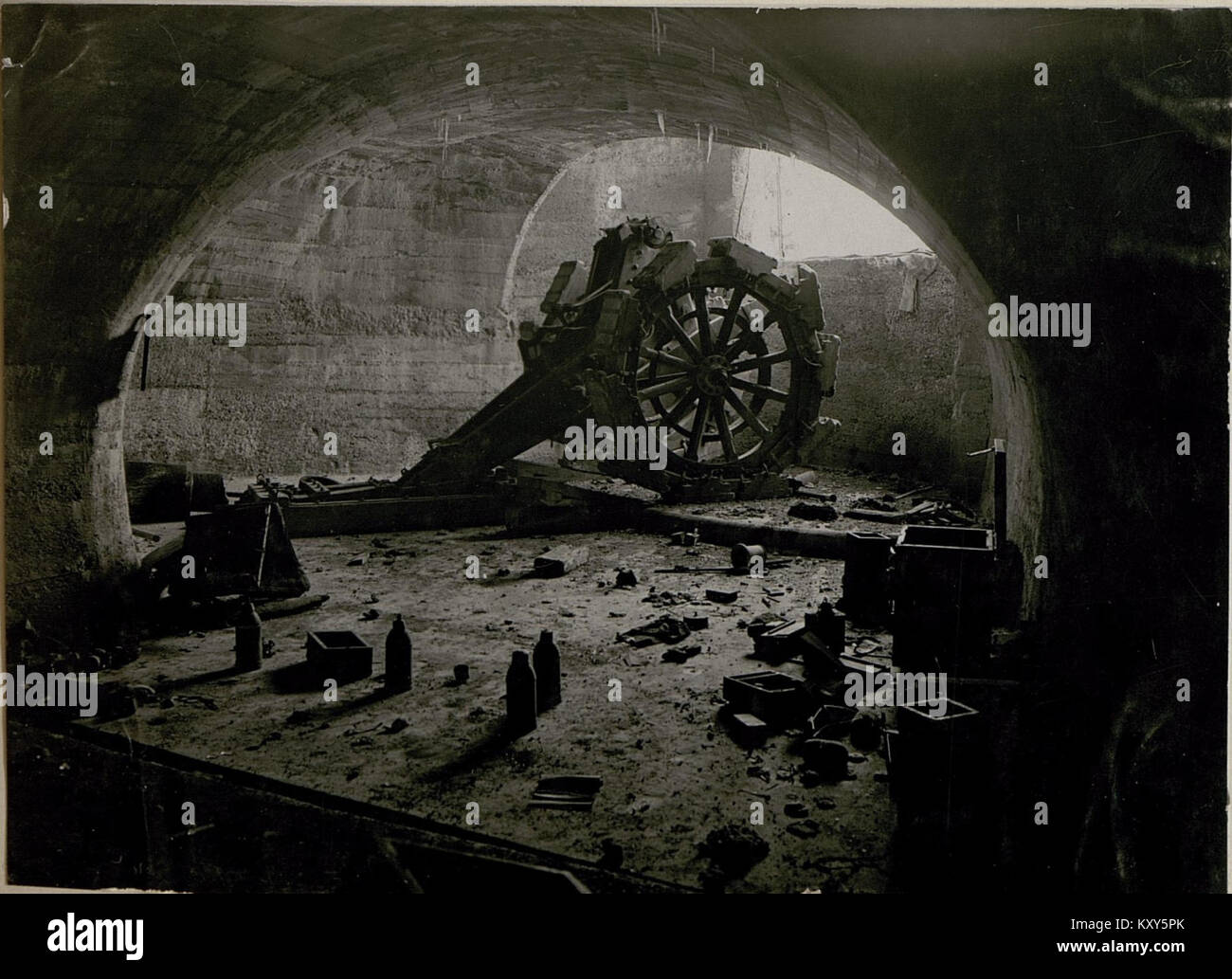 A wartime photograph showing a destroyed artillery piece in a gun ...