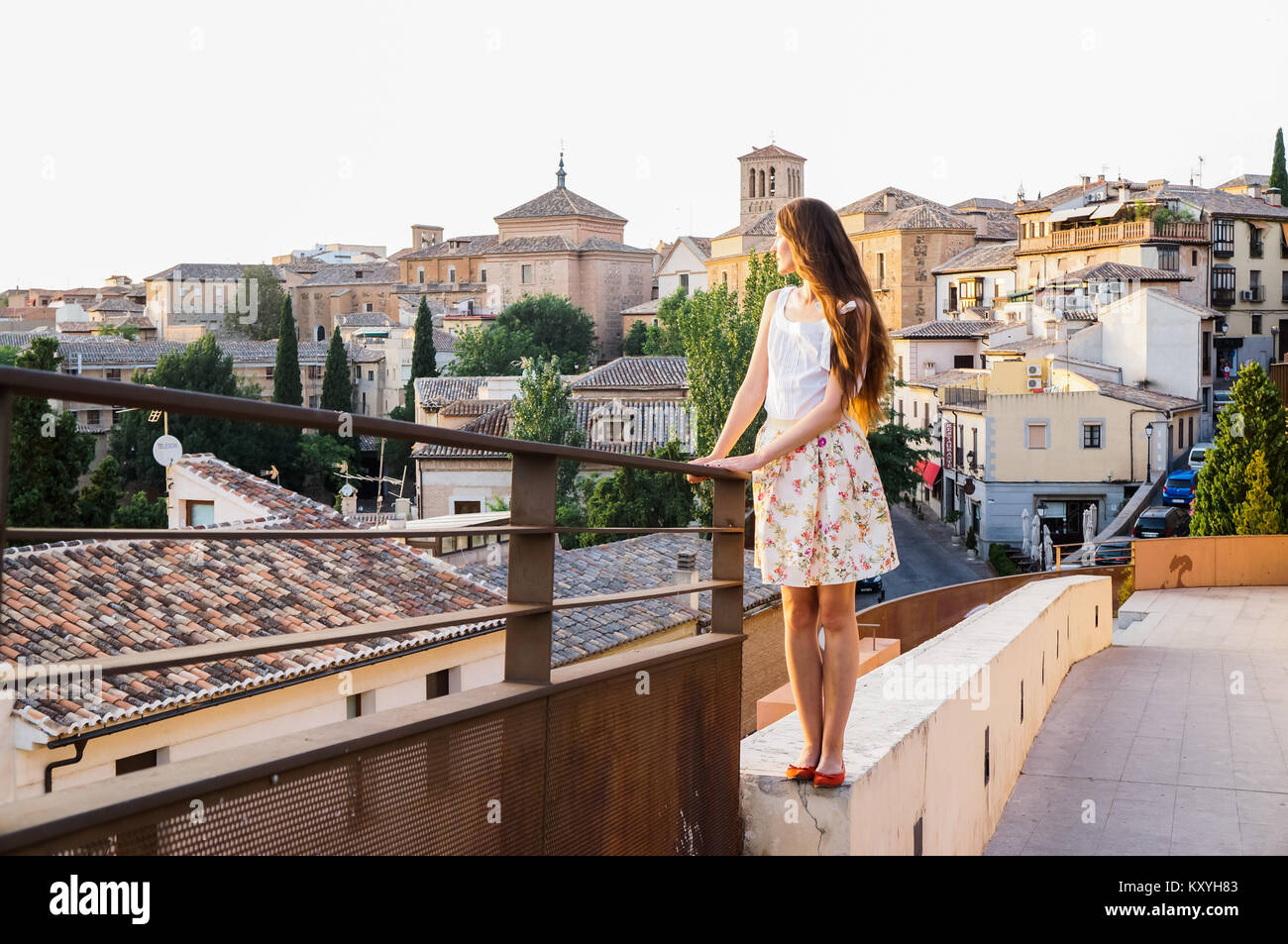 Beautiful young woman standing at sunset on the background of beautiful ...