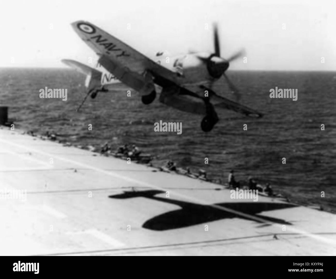 A Hawker Sea Fury aircraft is shown flying over HMAS Sydney (R17) in ...