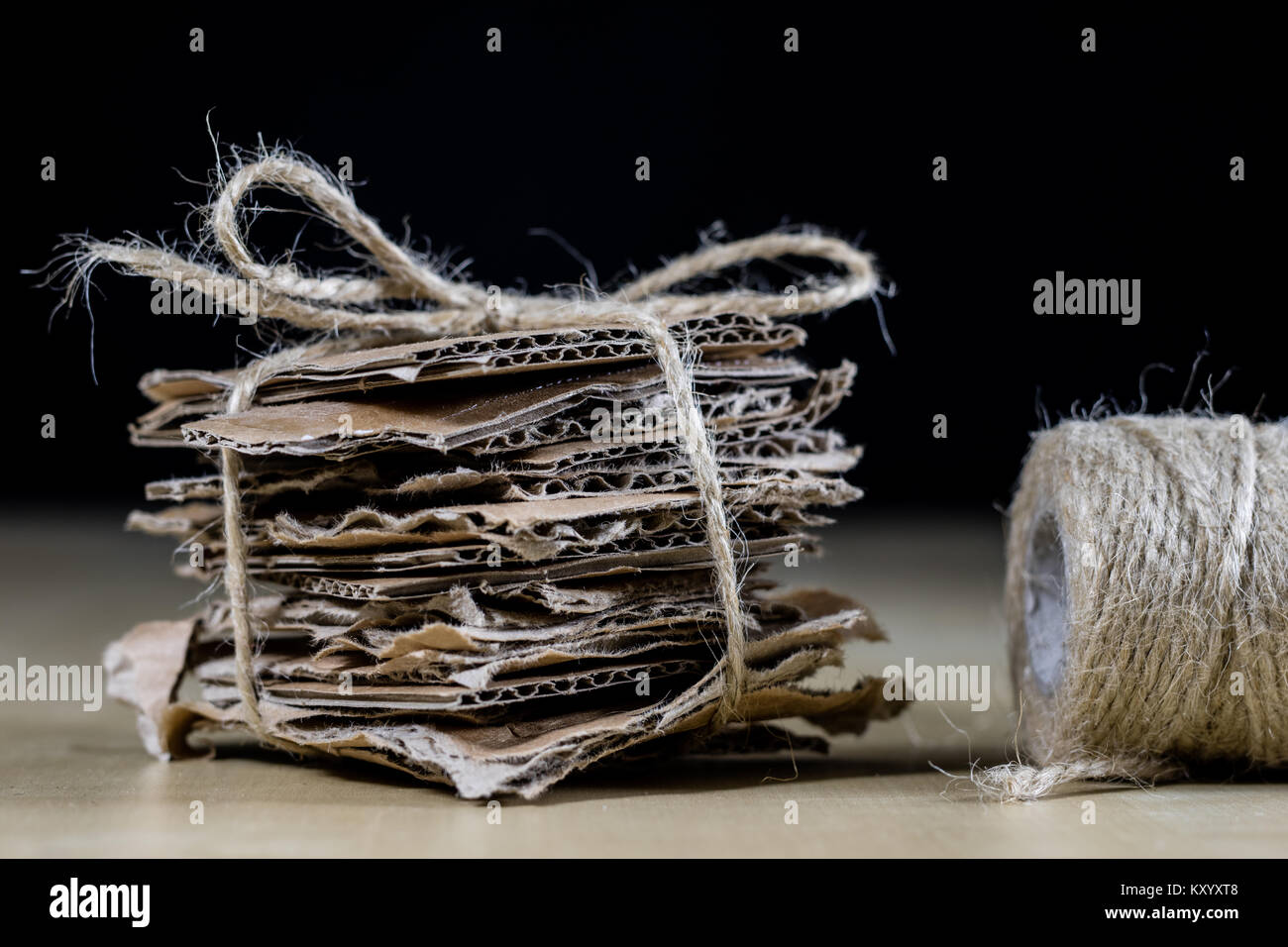 Cardboard pieces stacked and tied with a jute string. Waste paper ...