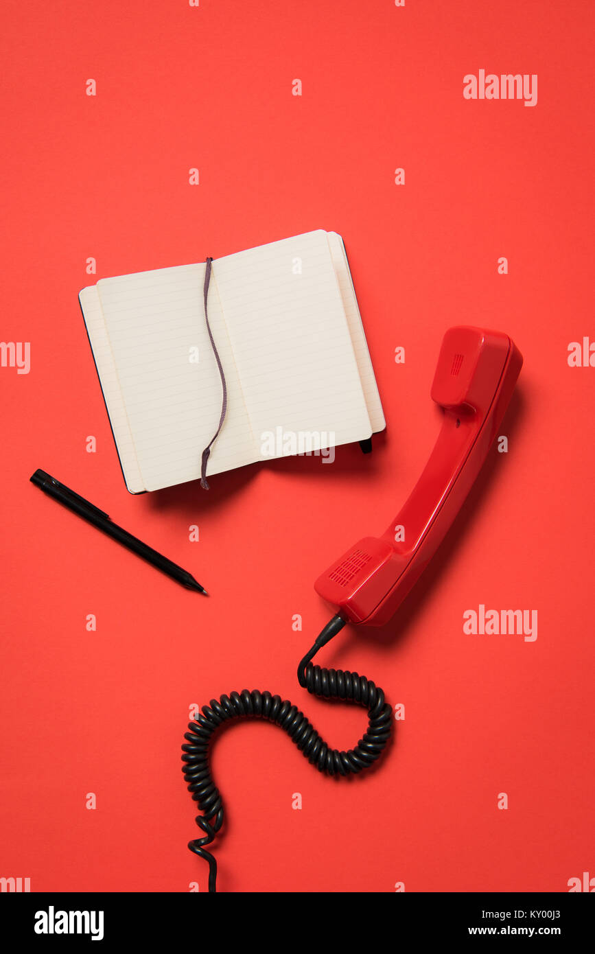 Close-up view of vintage telephone handset and blank open notebook with ...
