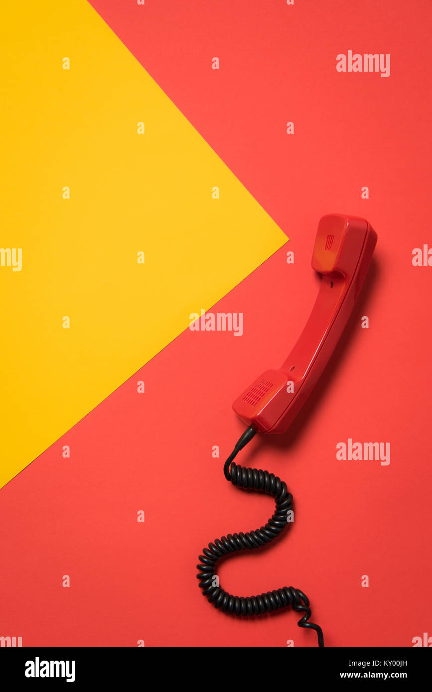 Close-up view of red telephone receiver with curly cord, communication ...