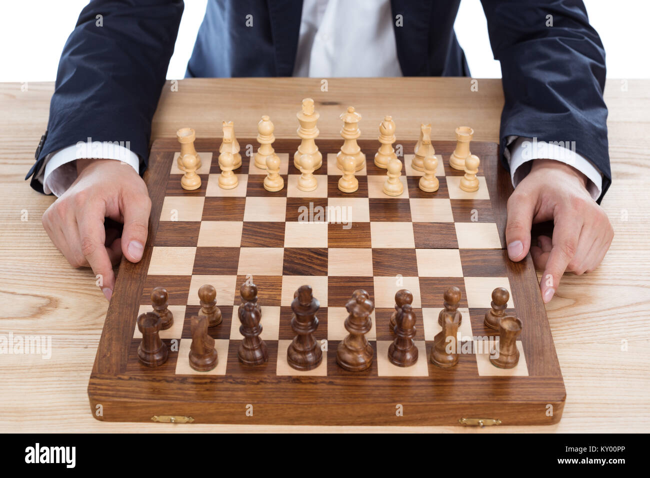 partial view of businessman sitting at table with chess board and ...