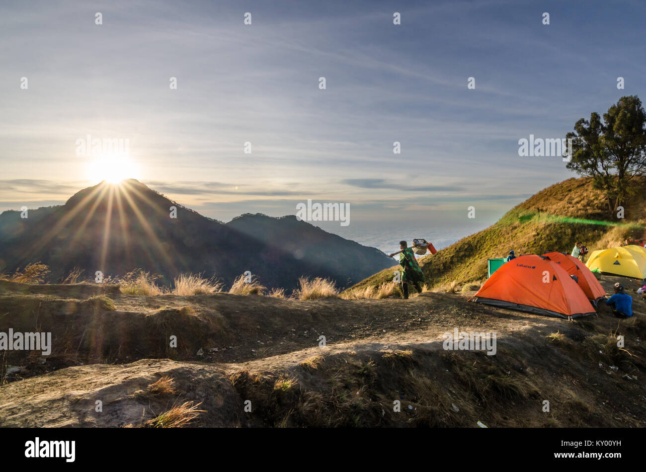 Porter of Mount. Rinjani helping hiker to carry stuff. The mountain is ...