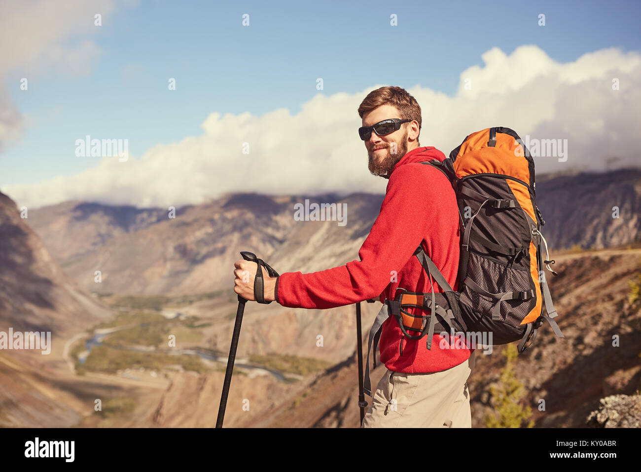 Time for thought. Handsome young bearded male hiker with sunglasses ...