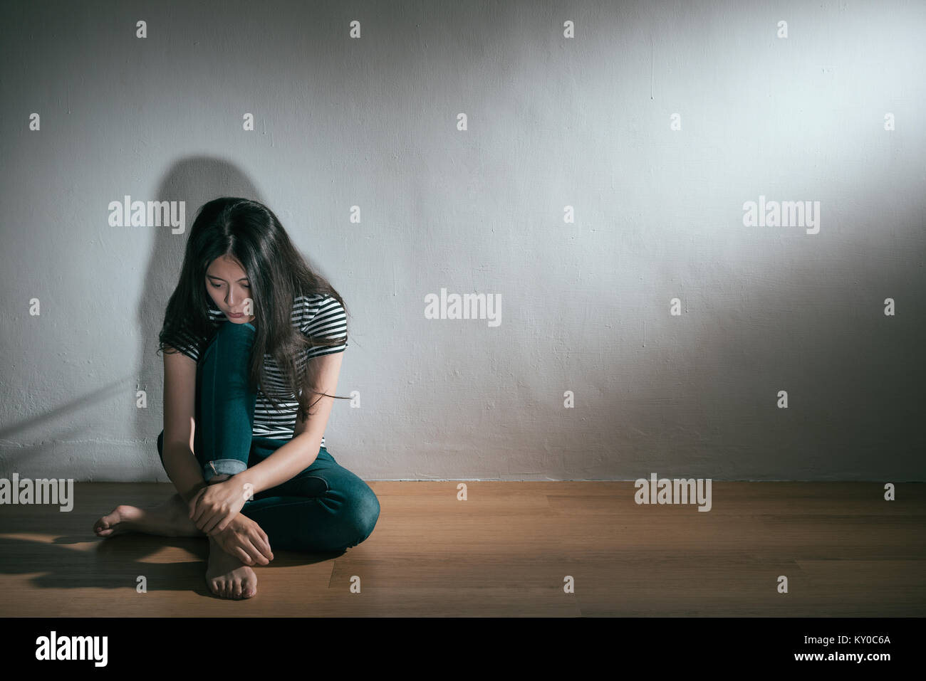 unhappy beauty girl feeling helpless sitting on wooden floor resting in ...