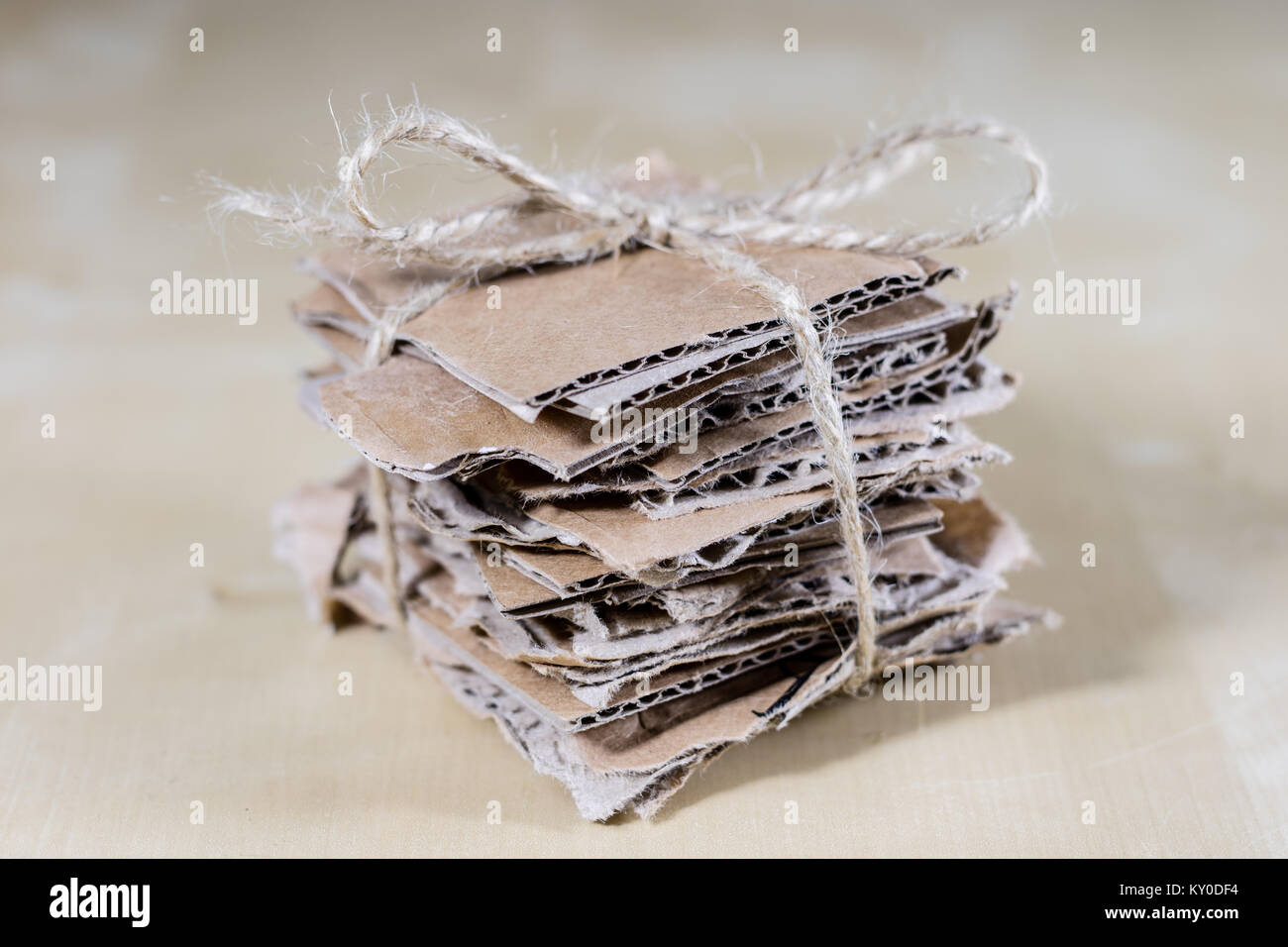 Cardboard pieces stacked and tied with a jute string. Waste paper ...