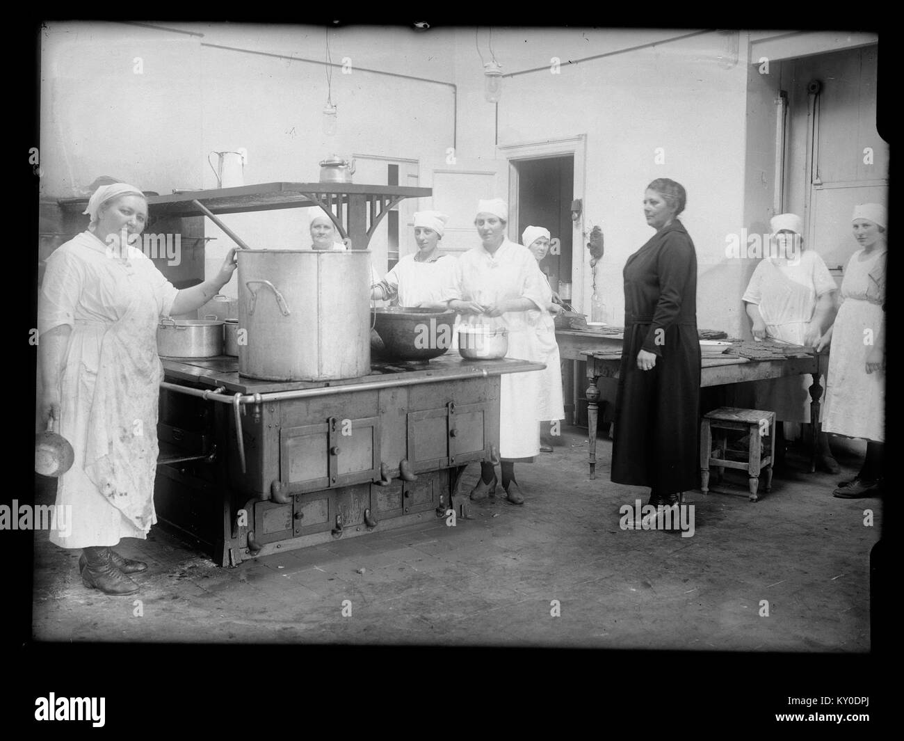 This photograph 'Hjemmenes Vel, Kjøkken' depicts a traditional ...