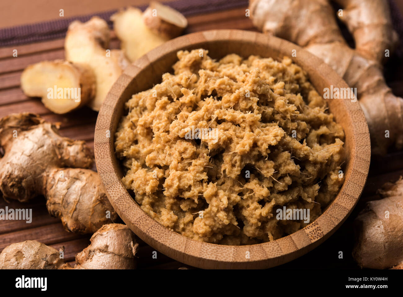 Fresh mashed Ginger puree / Adrak paste in white bowl with raw whole ...