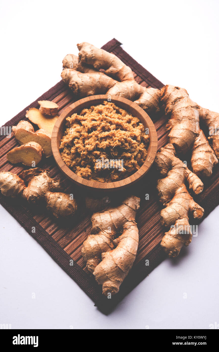 Fresh mashed Ginger puree / Adrak paste in white bowl with raw whole ...