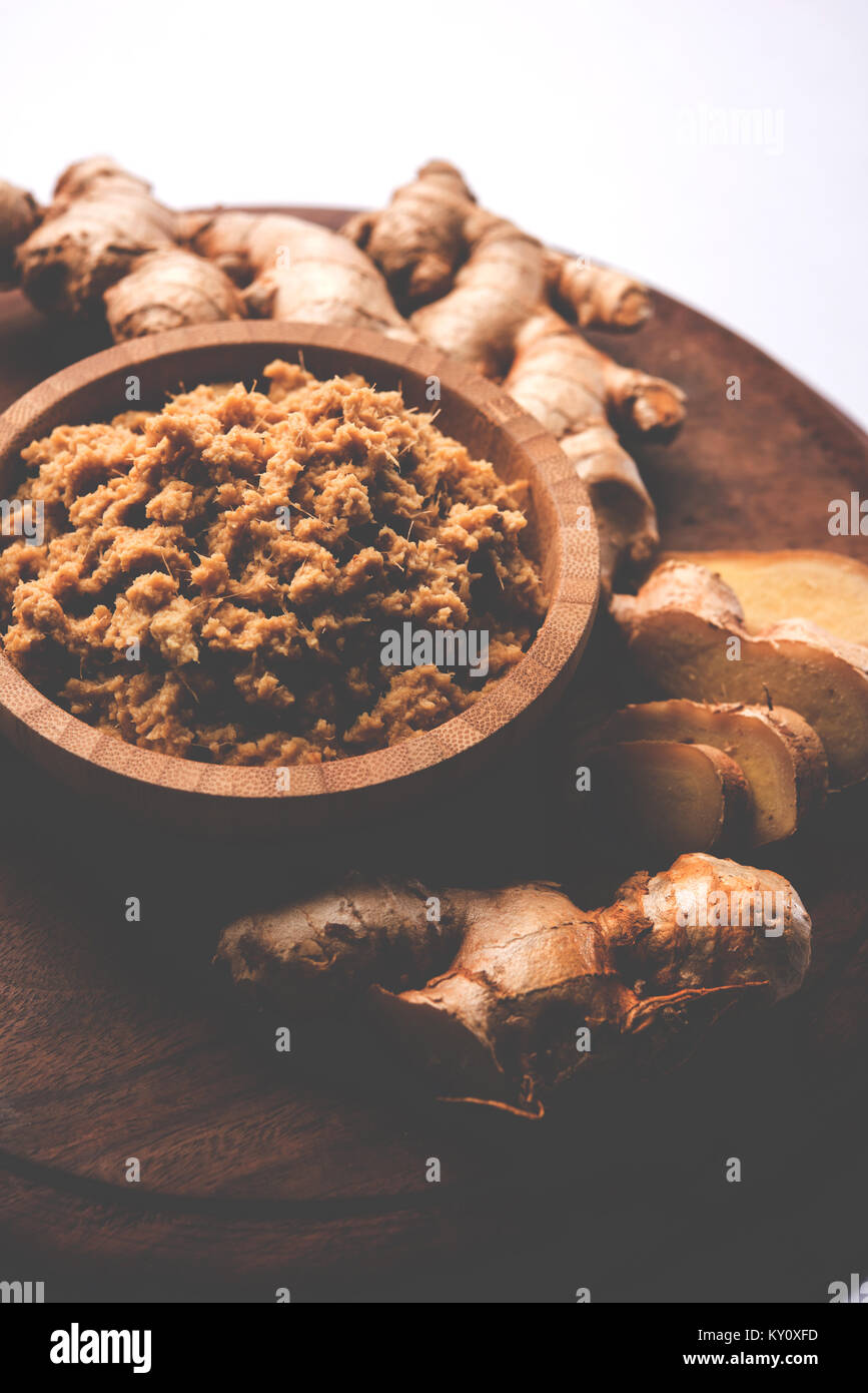 Fresh mashed Ginger puree / Adrak paste in white bowl with raw whole ...