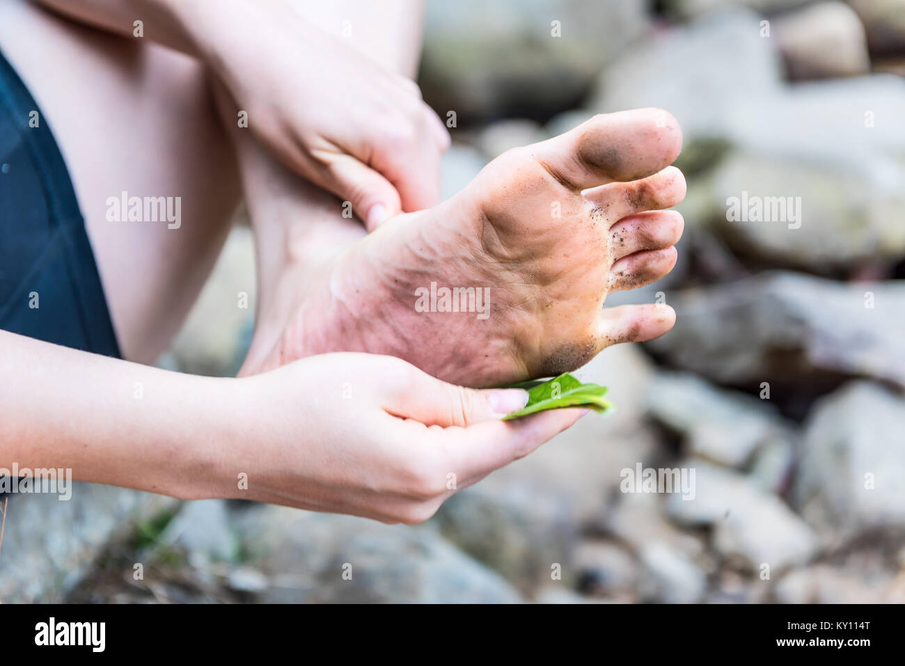 Closeup of young woman's dirty foot with her cleaning dirt with green ...