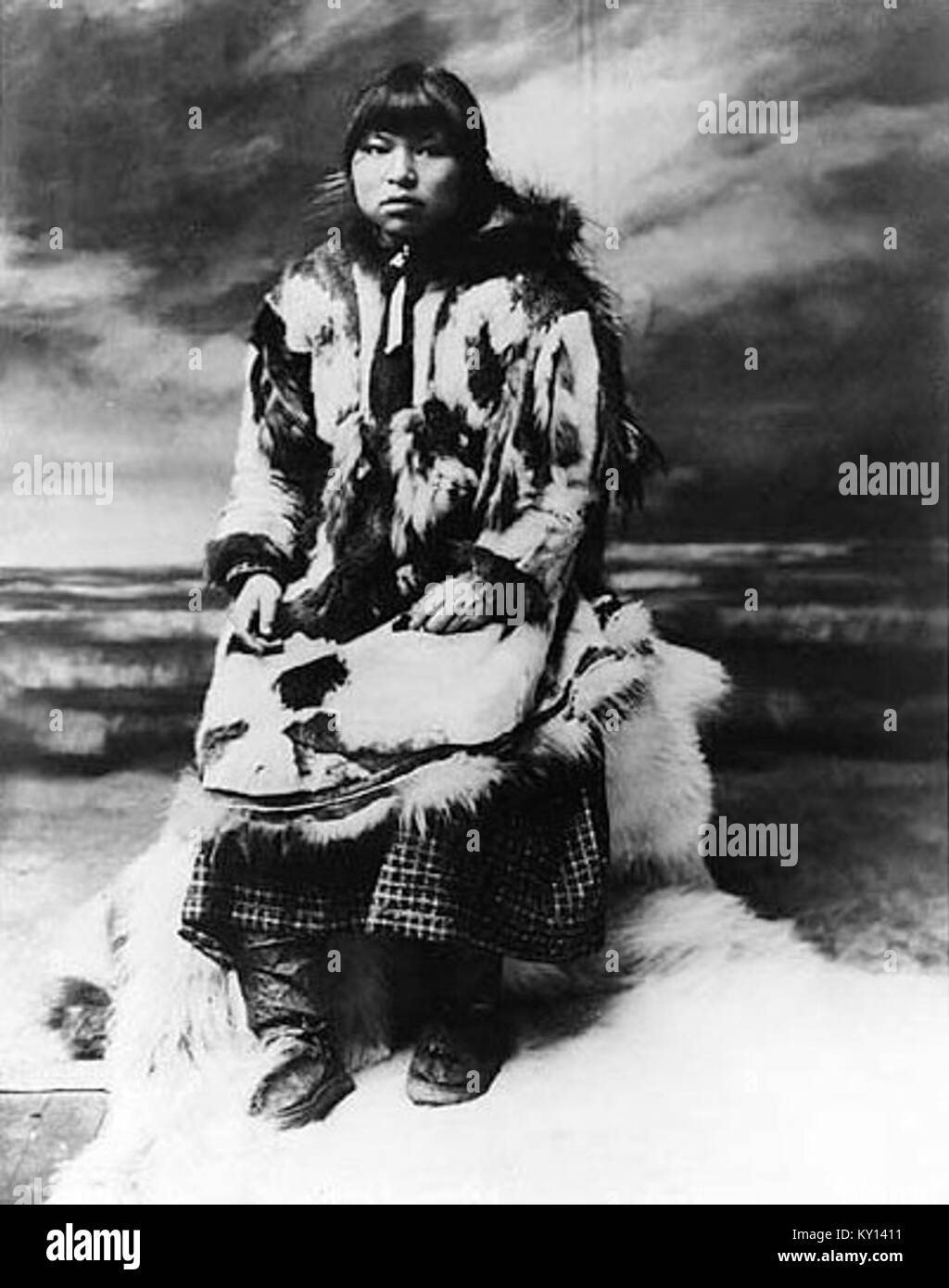 This photograph depicts an Eskimo woman in Alaska around 1901, wearing ...