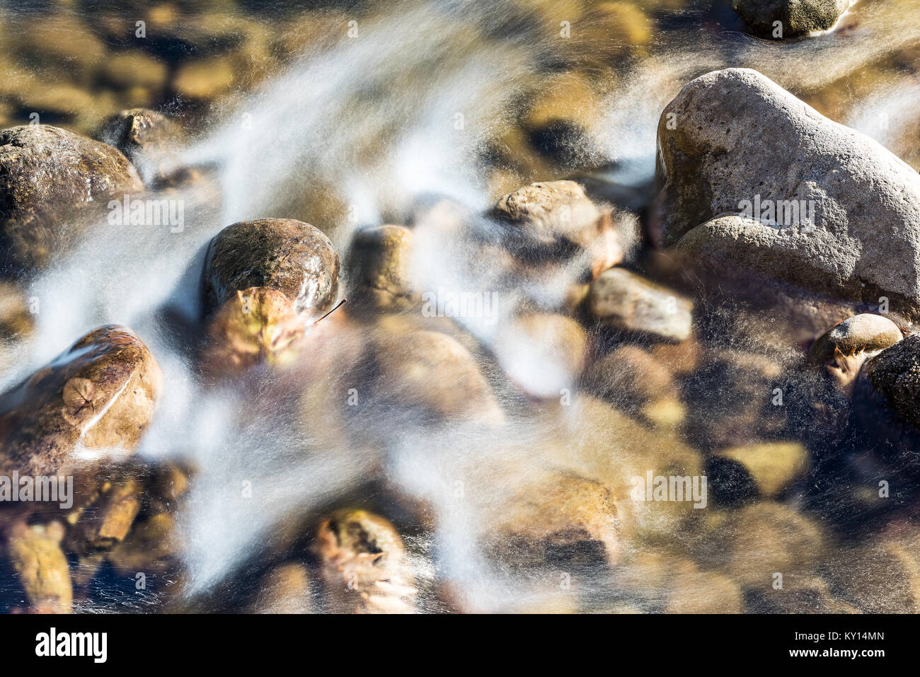 Closeup of shallow rock stream with running splashing water long ...