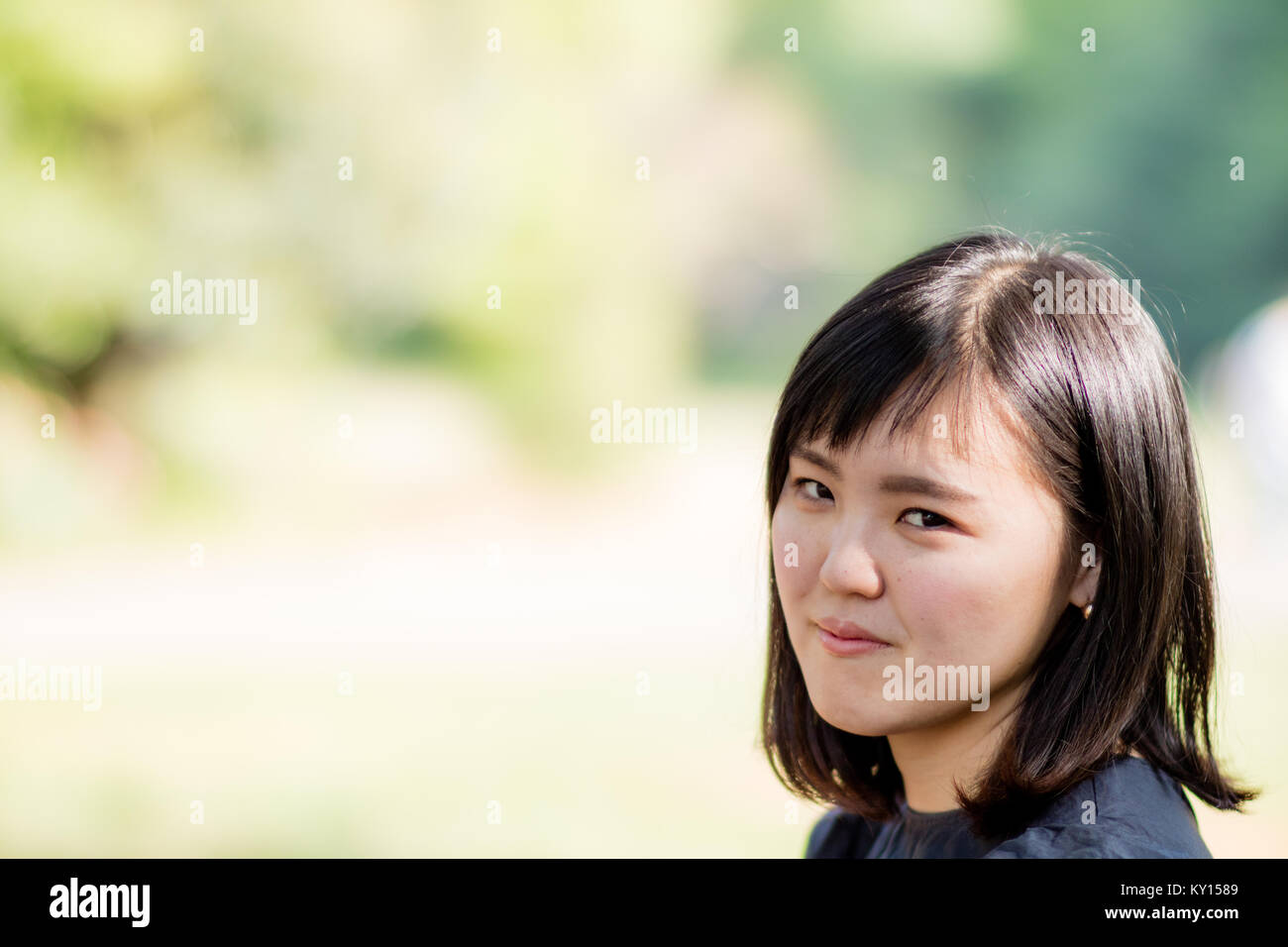 A beautiful Japanese lady in the park looking at the camera Stock Photo ...