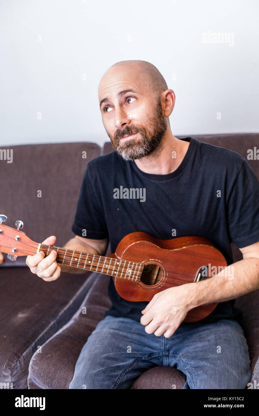 BALD MAN WITH BEARD PLAYS LEFT HANDED UKULELE. SCHULTZ THE PUPPET OVER ...