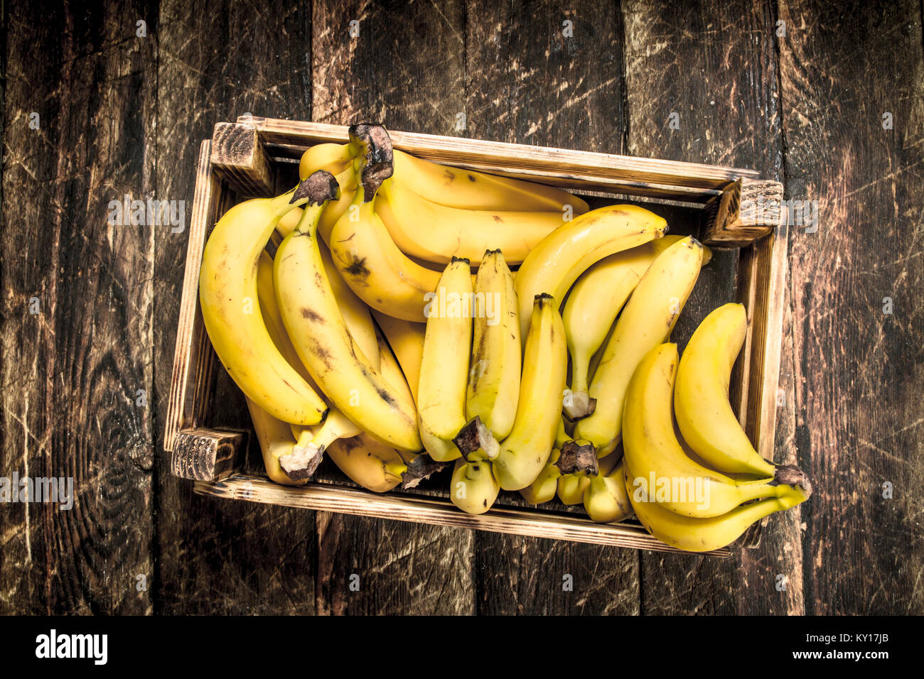 box of fresh bananas. On a wooden background Stock Photo - Alamy