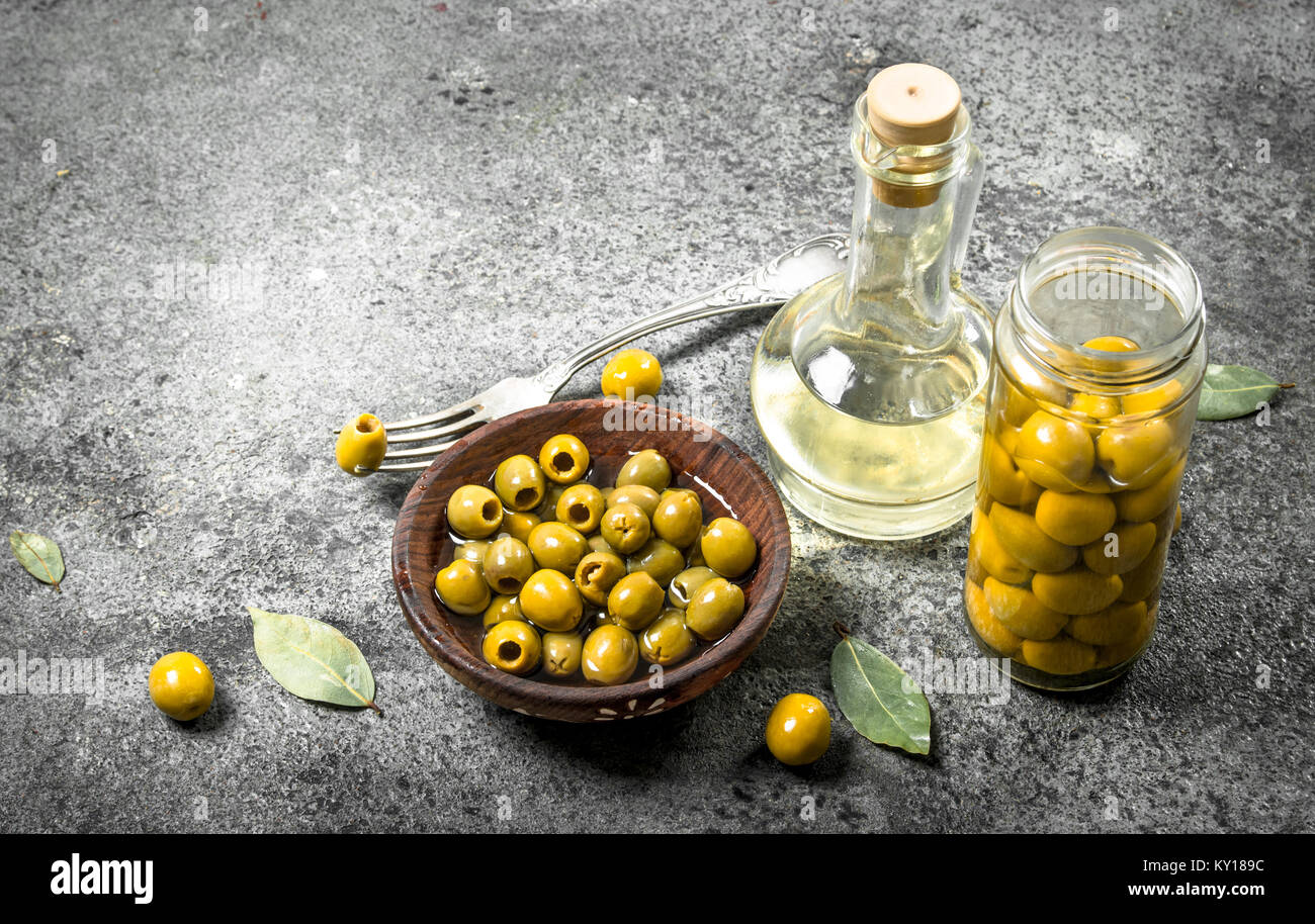Pickled olives with olive oil. On a rustic background Stock Photo - Alamy