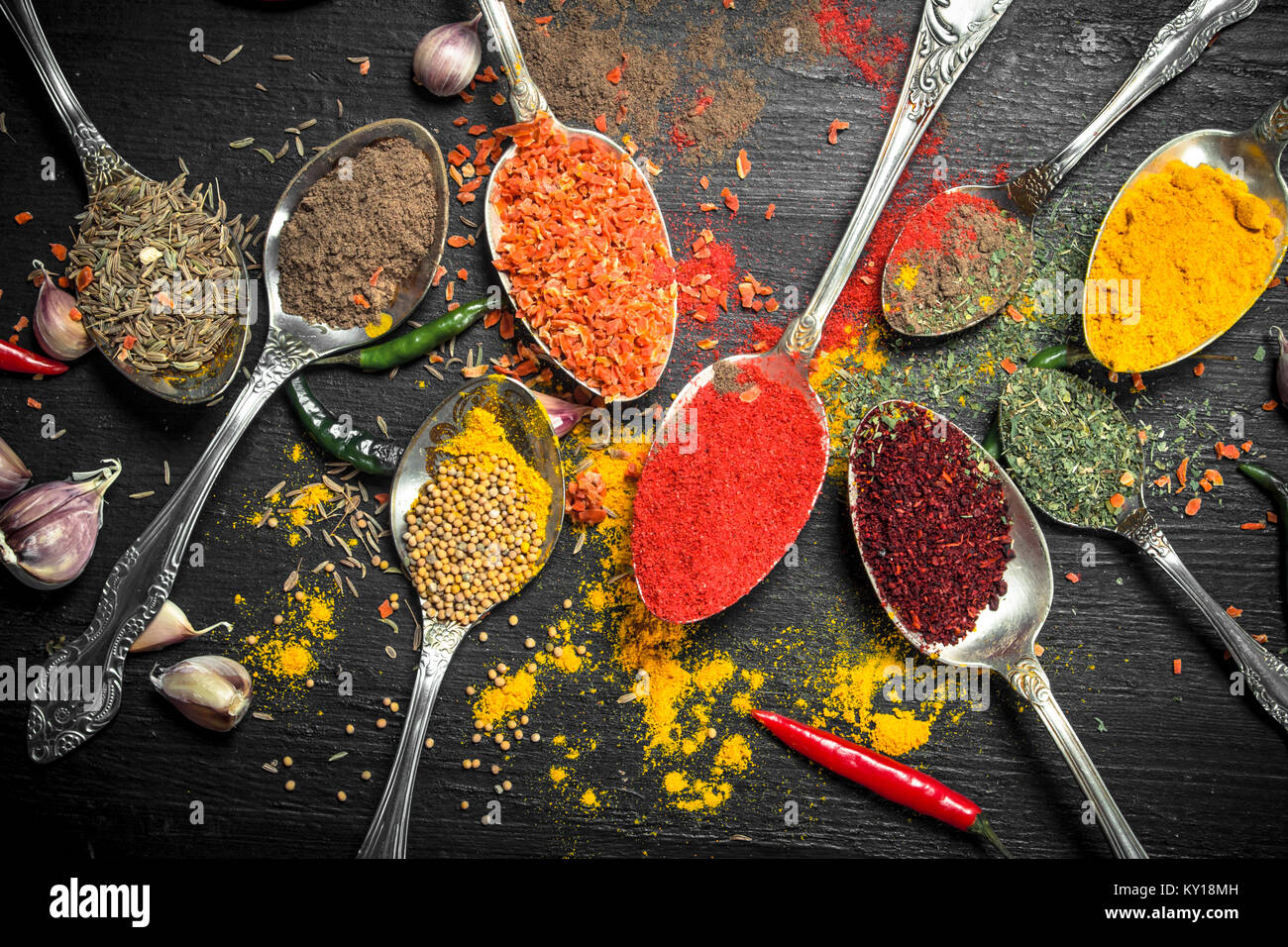 Ground spices and herbs in spoons. On the black chalkboard Stock Photo ...