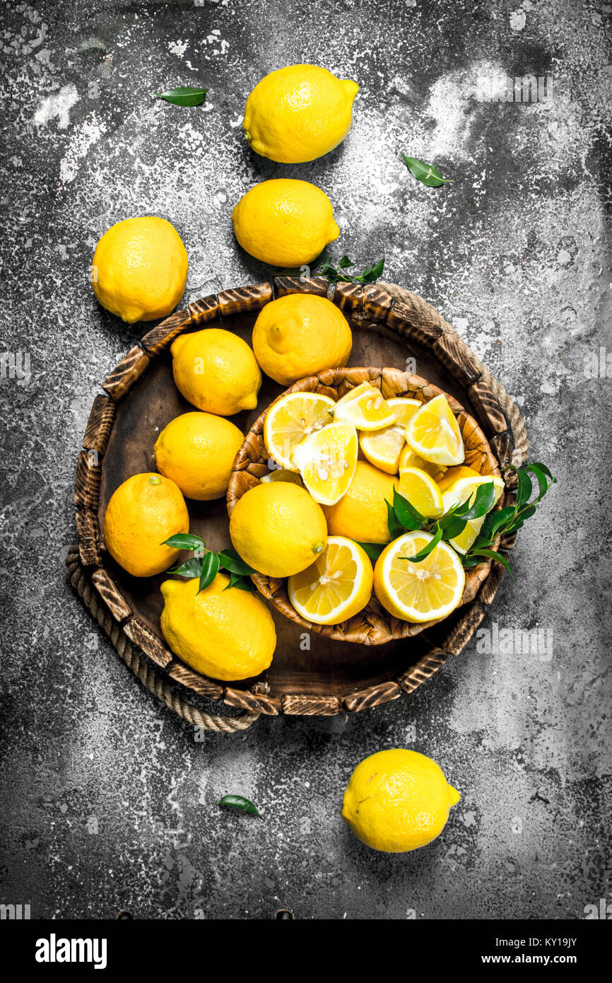 Fresh lemons on a tray. On a rustic background Stock Photo - Alamy