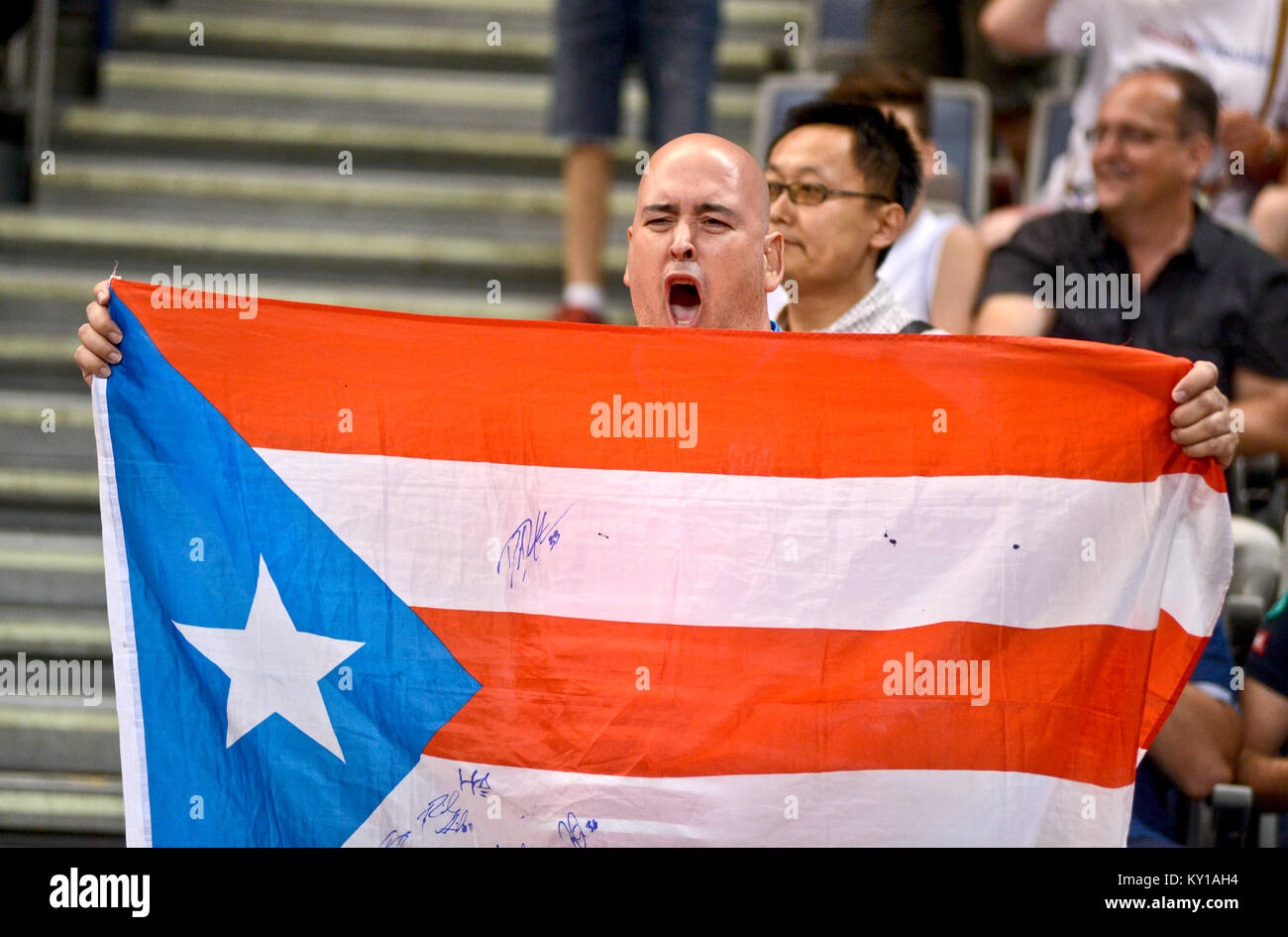 Puerto Rican fan during a basketball game with a flag signed by the ...