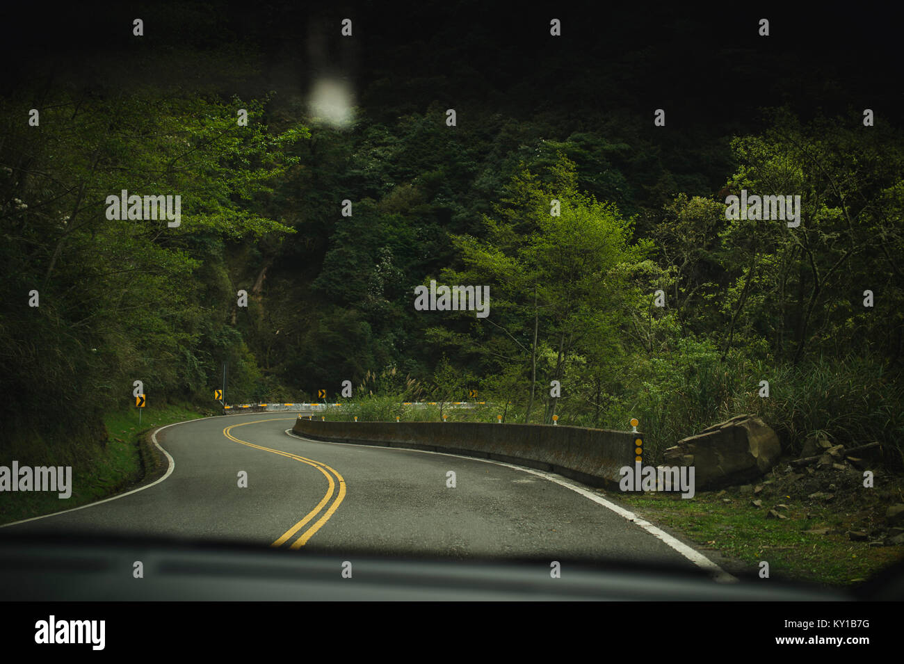 A road curves into the background seen through the window of a car ...