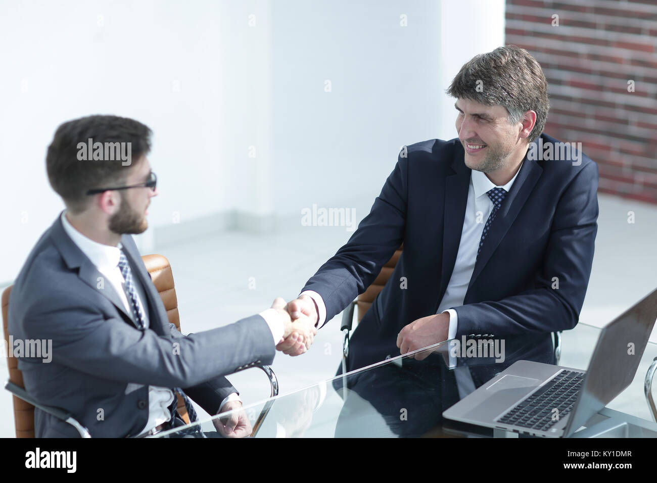 Business people handshake, sitting at the table Stock Photo - Alamy