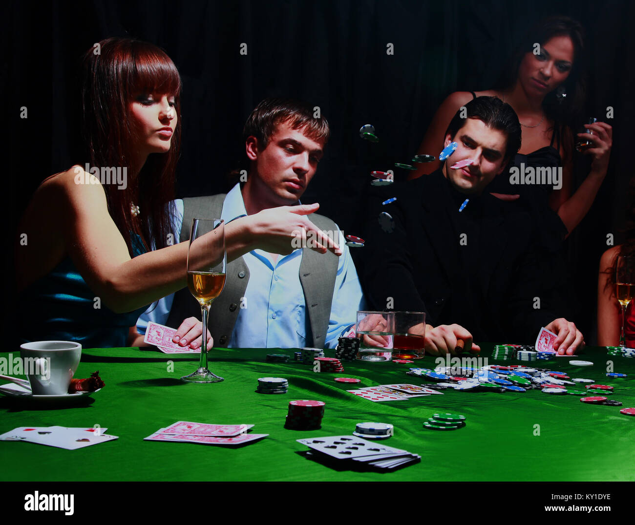 Young women throwing chips on the table while playing cards Stock Photo ...