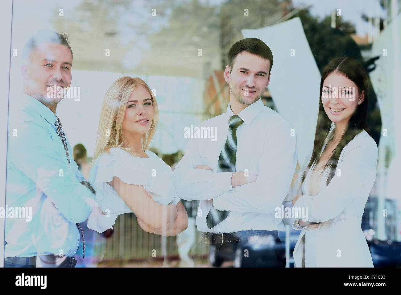 Happy smiling business team looking through window Stock Photo - Alamy
