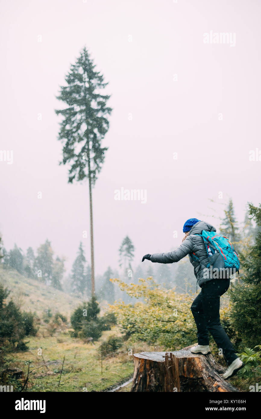Young Woman Jumping On Stump In Woods. Back View Stock Photo - Alamy