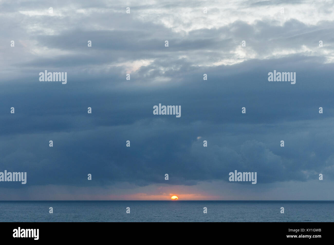 Image of sea, red sun, cloudy sky Stock Photo - Alamy