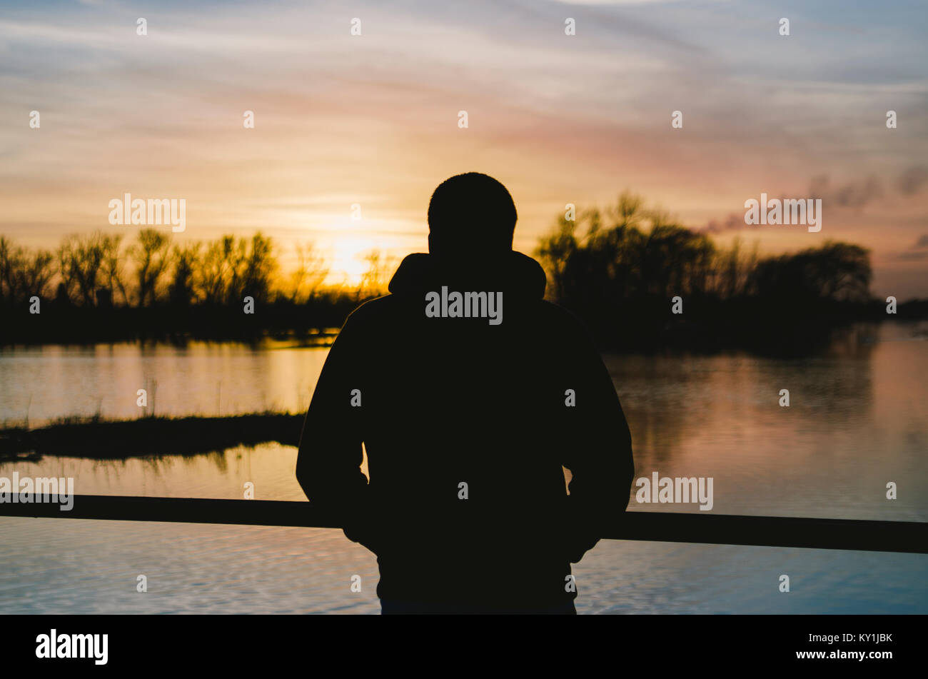 Silhouette of man overlooking flooded fields in the Whittlesey fens at ...