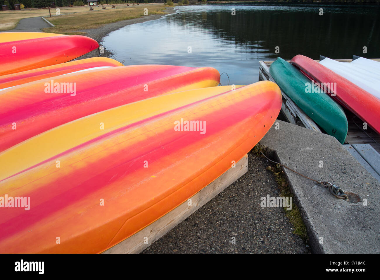 Colorful kayaks on a lake shore Stock Photo - Alamy