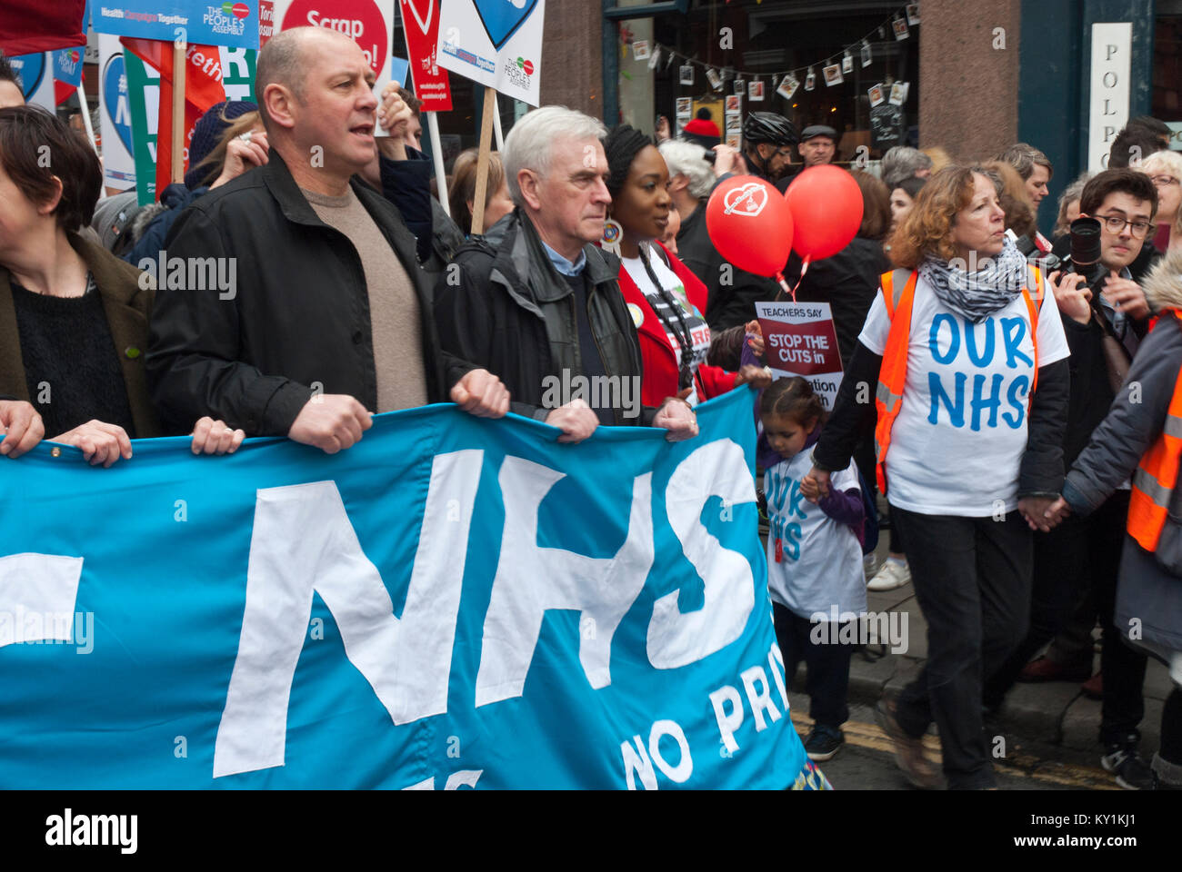Lead banner of demonstration "Our NHS", colourful with many people and ...