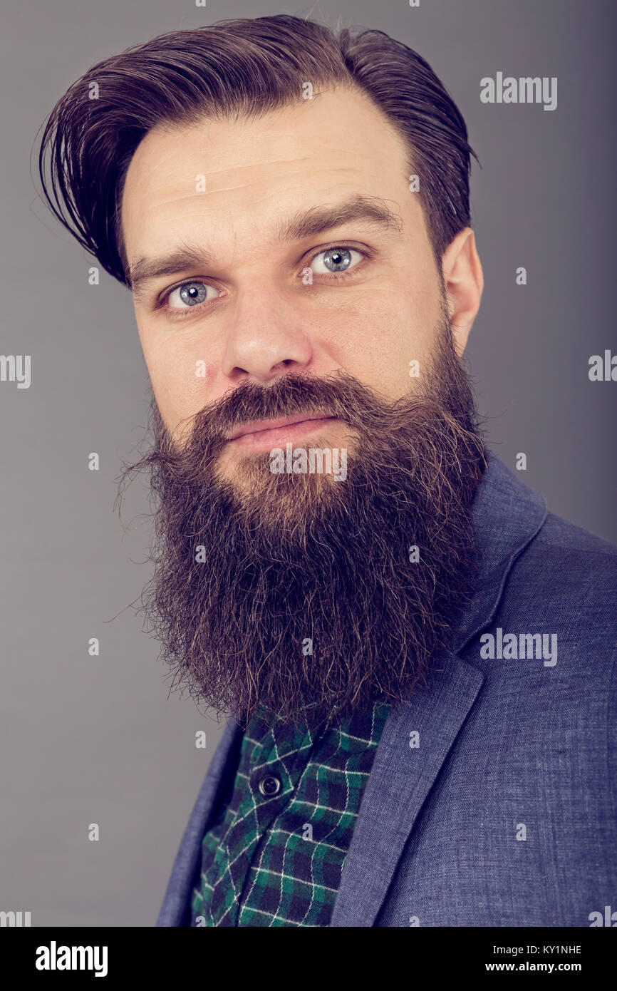 Portrait of an elegant young fashion man with beard and mustache posing ...