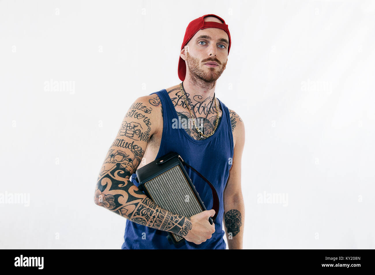 standing tattooed rap singer posing in studio with an amplified radio ...