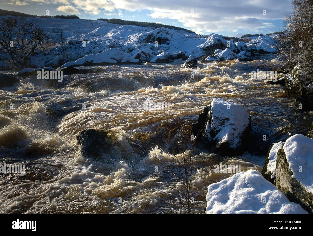 Scottish Highland river in winter spate from snow melt .River runs from ...